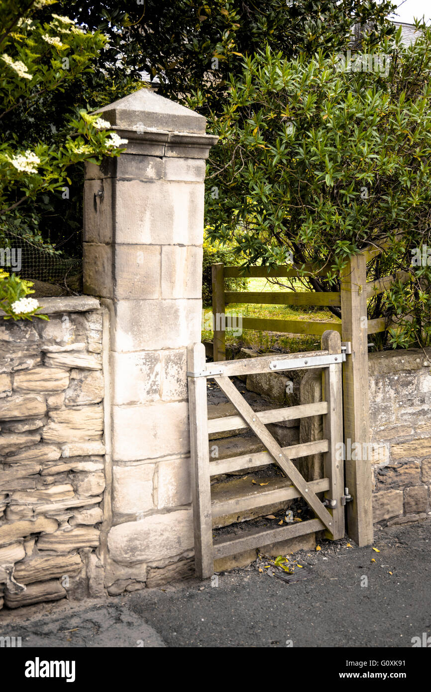 A wooden gate next to an stone gate post Stock Photo - Alamy