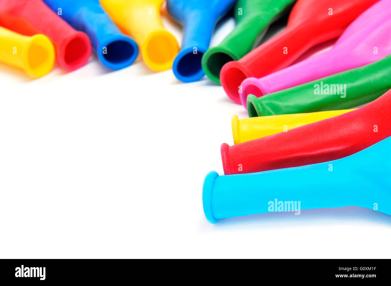 a pile of uninflated balloons of different colors on a white background ...