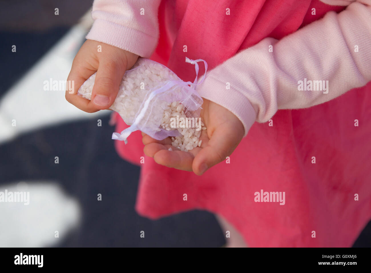 Sachet of white rice on child hands ready to throw away after a wedding ...