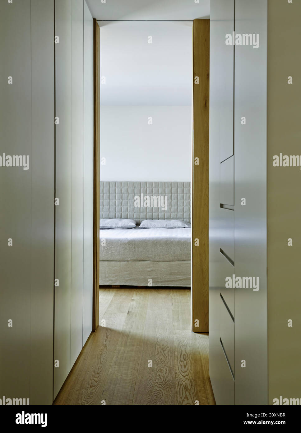 Partial view of a hallway leading into bedroom. Modern white interior ...