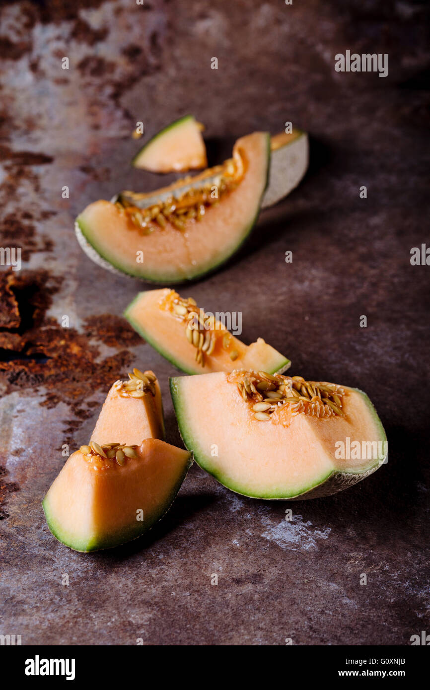 Melon slices in rusty metal background Stock Photo - Alamy