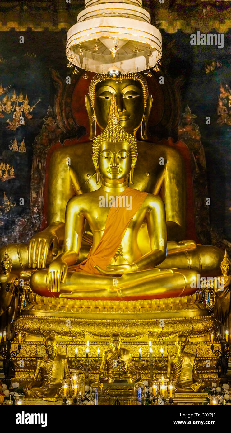 Theravada buddhist altar with golden Buddhas meditating. They are ...