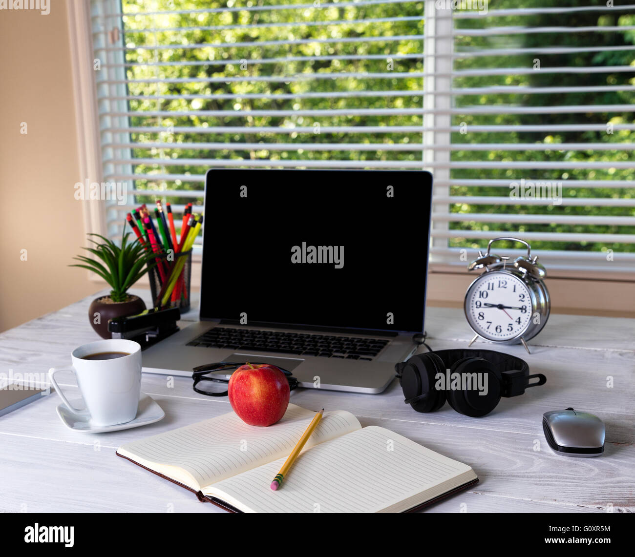 Working desktop in front of large window with bright daylight and trees ...