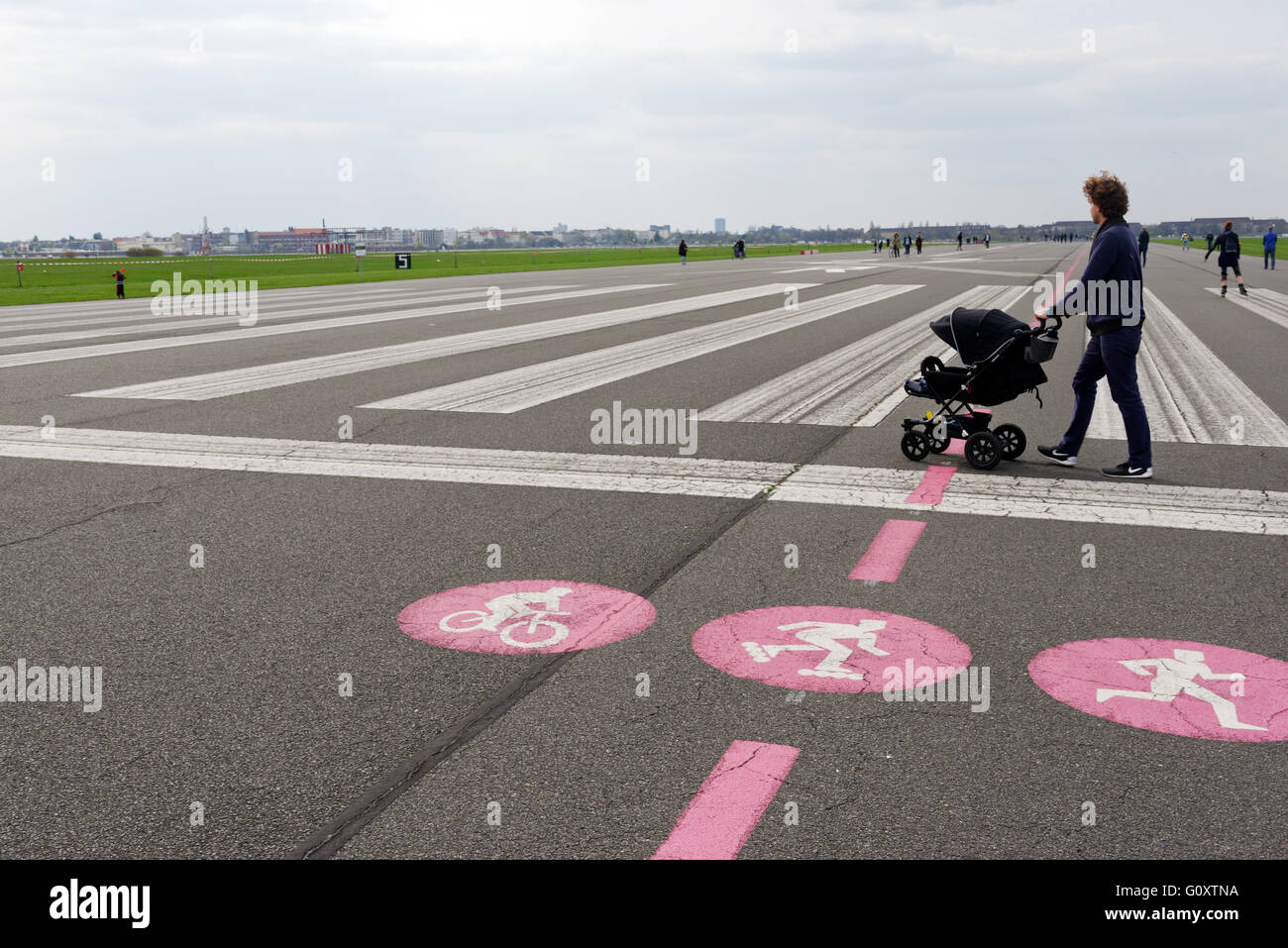 A man pushing a pushchair on the runway at Tempelhof airfield park in ...
