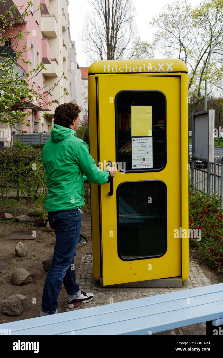 A man going into a BucherBoxx book exchange booth in Berlin Stock Photo ...