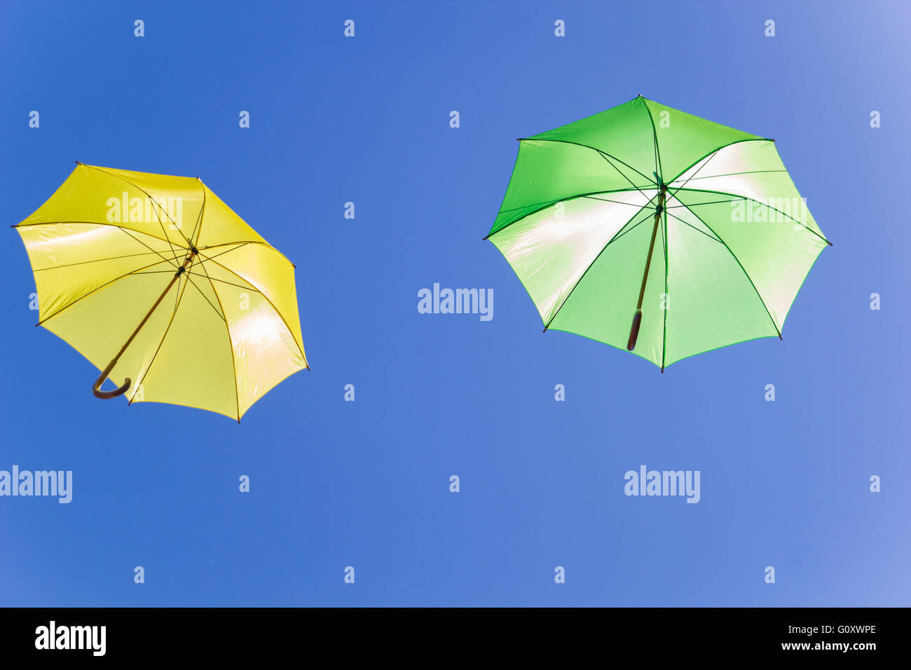 Colorful umbrellas fly in the sky on blue background Stock Photo - Alamy