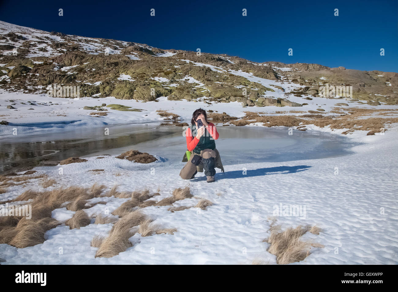 brunette woman with green, red and brown clothes crouching looking to ...