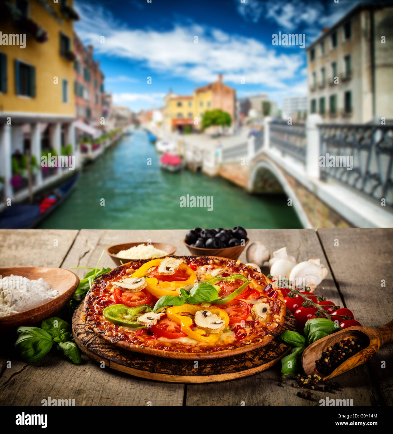 Rustic pizza with mozzarella, olives, basil and ham served on vintage ...