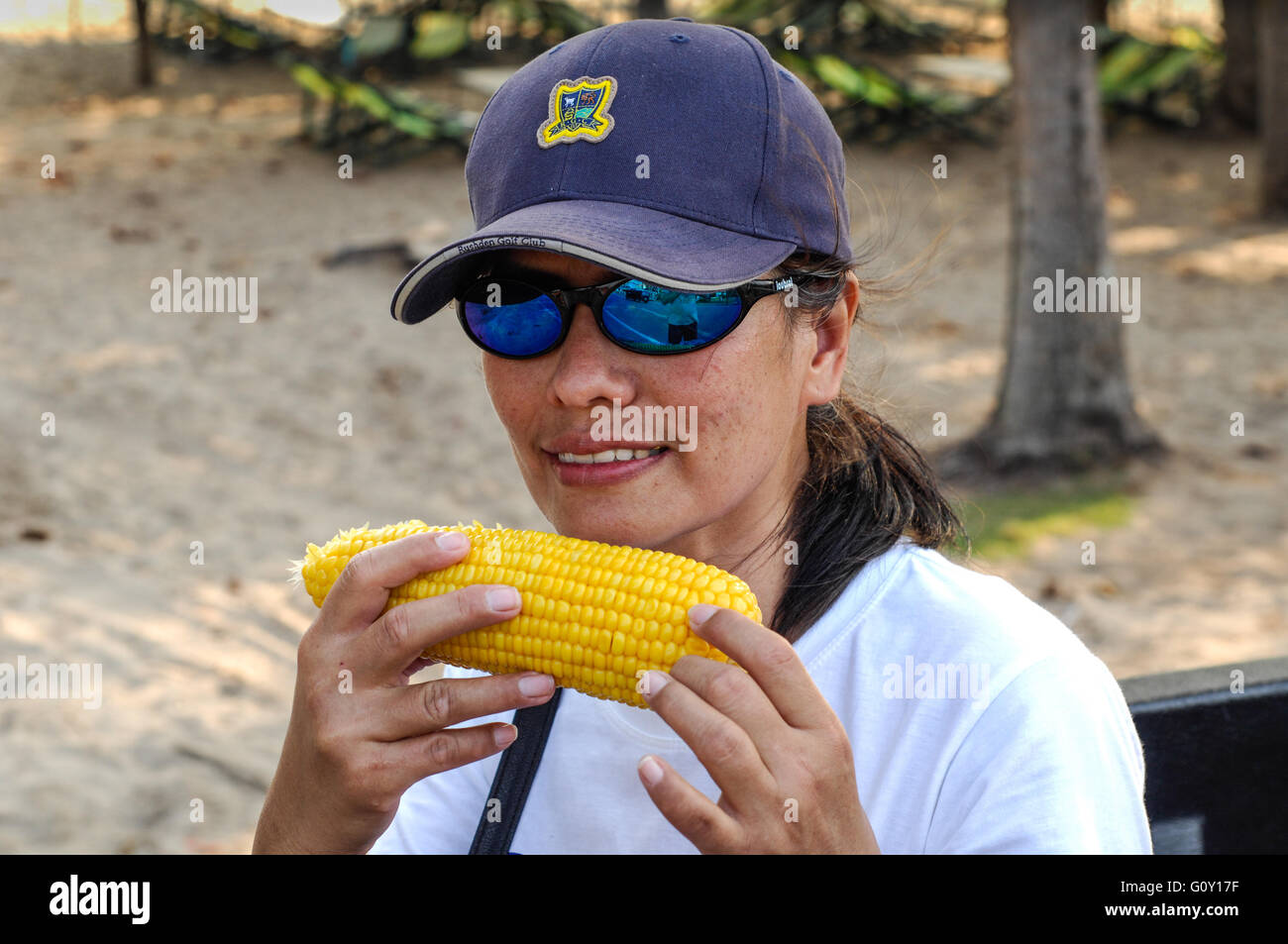 Woman eating sweetcorn Stock Photo - Alamy