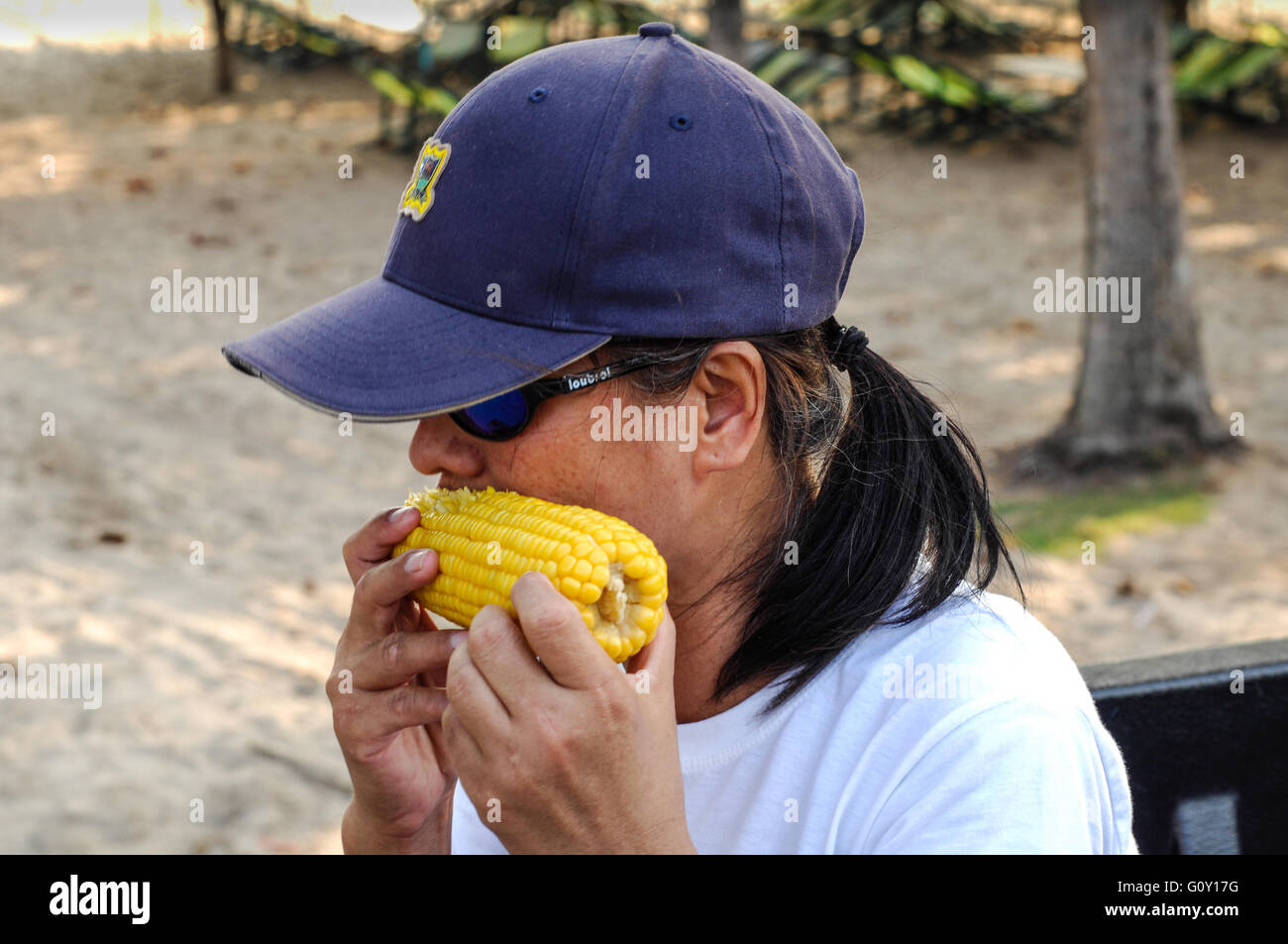 Woman eating sweetcorn Stock Photo - Alamy