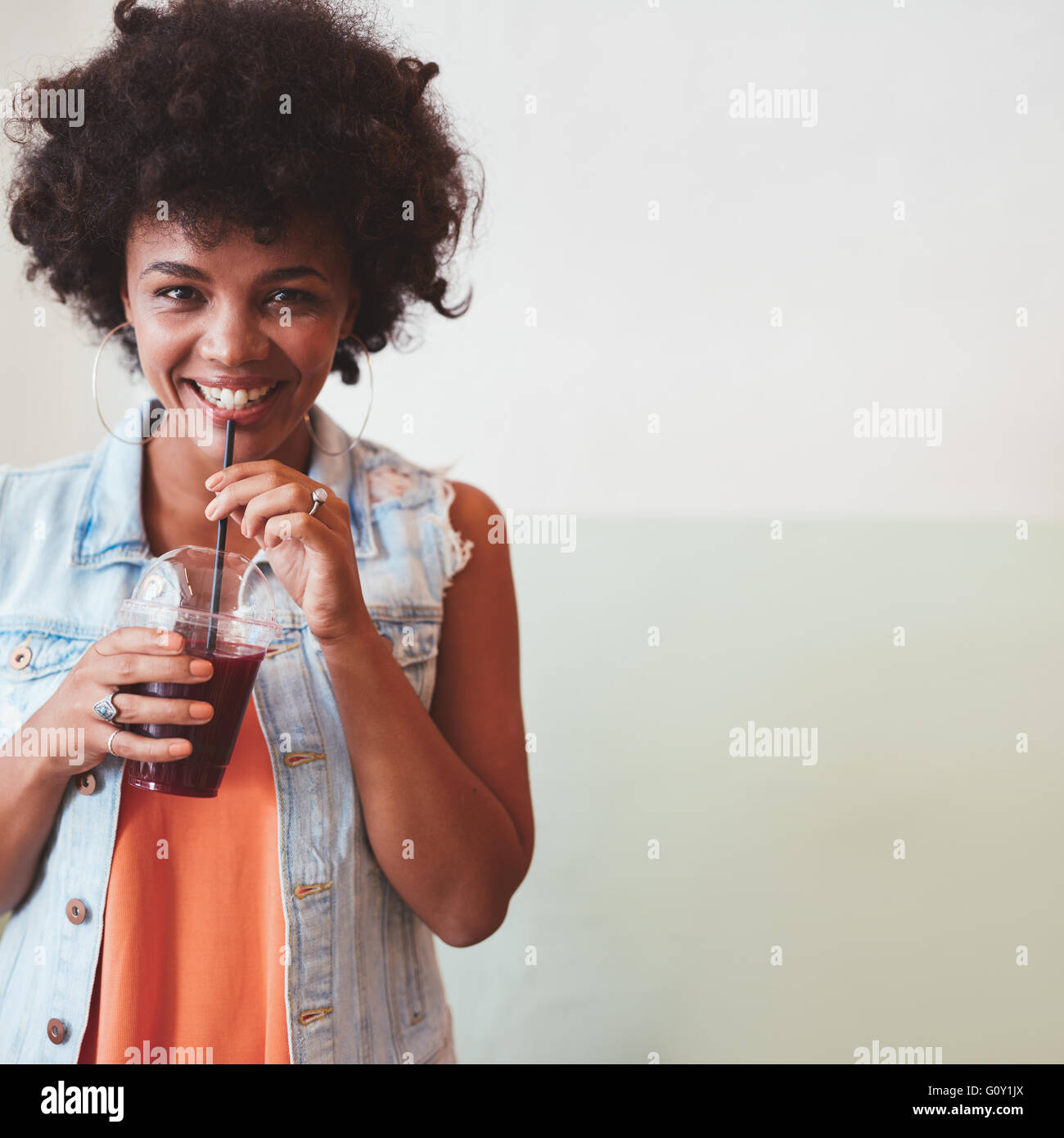 Portrait of happy young african woman having a fresh fruit juice. Young ...