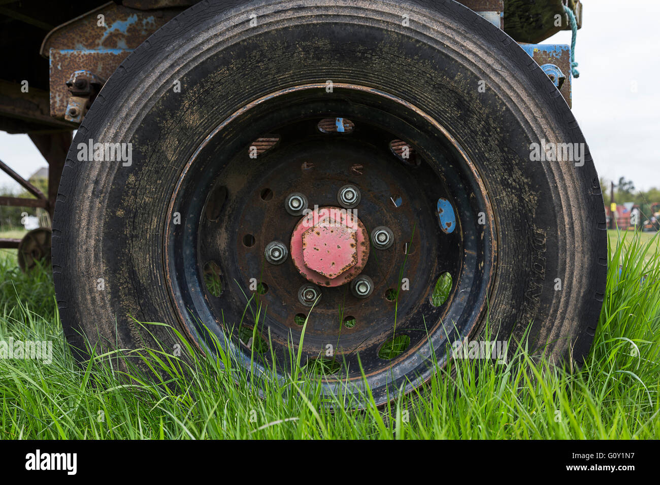 Old trailer wheel in overgrown grass Stock Photo - Alamy