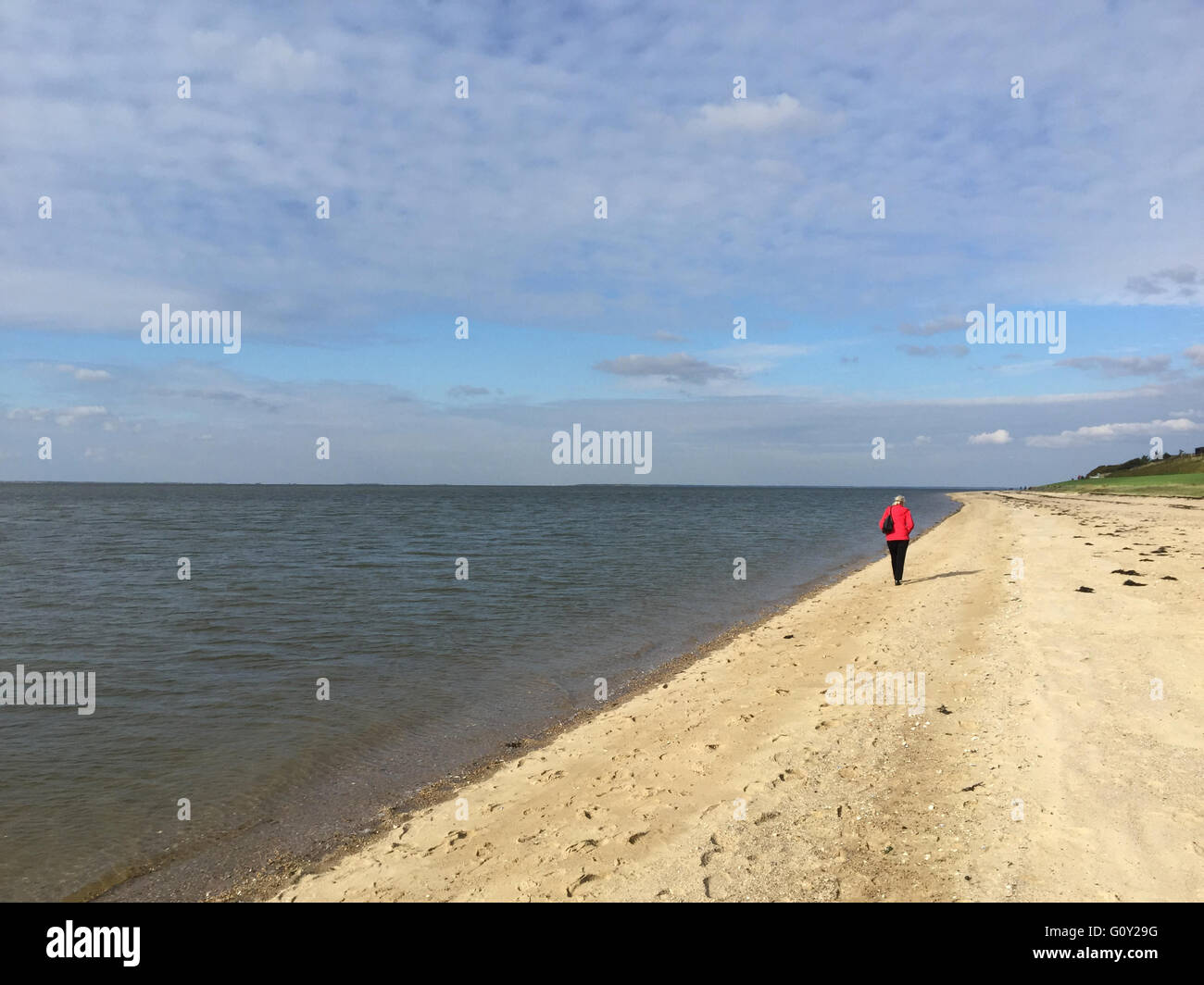 rear view of senior woman walking along beach, Esbjerg, Denmark Stock ...