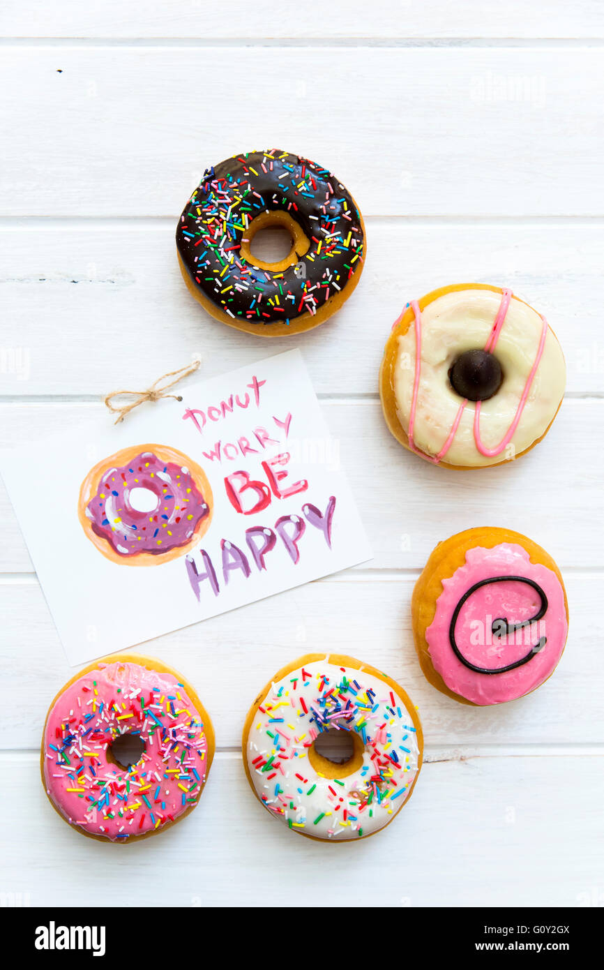 Selection of donuts with multi coloured icing with note Stock Photo - Alamy
