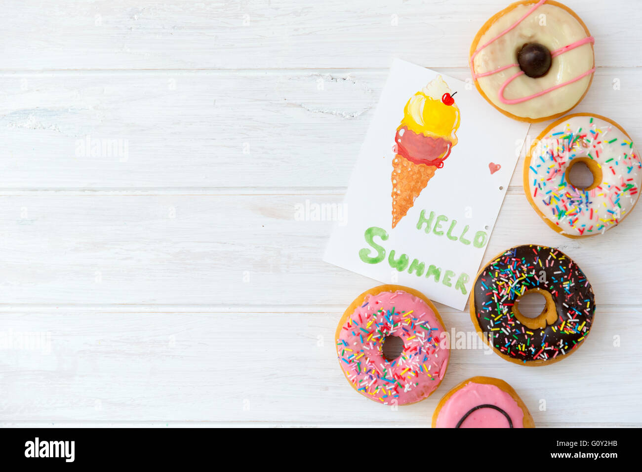 Selection of donuts with multi coloured icing with note Stock Photo - Alamy