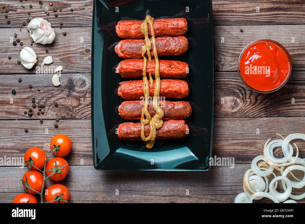 Roasted sausage in black plate on wooden table. Top view Stock Photo ...
