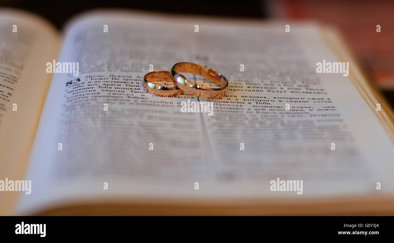 Two wedding rings on a bible Stock Photo - Alamy