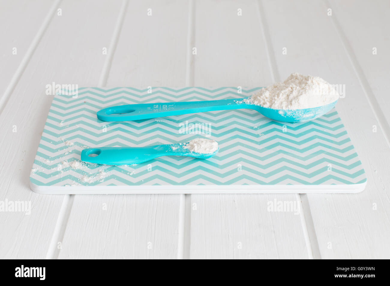Two measuring spoons with flour in kitchen Stock Photo - Alamy