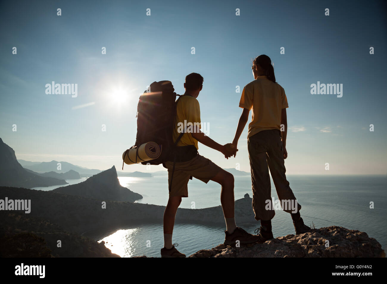 Couple looking at beautiful sunrise Stock Photo - Alamy