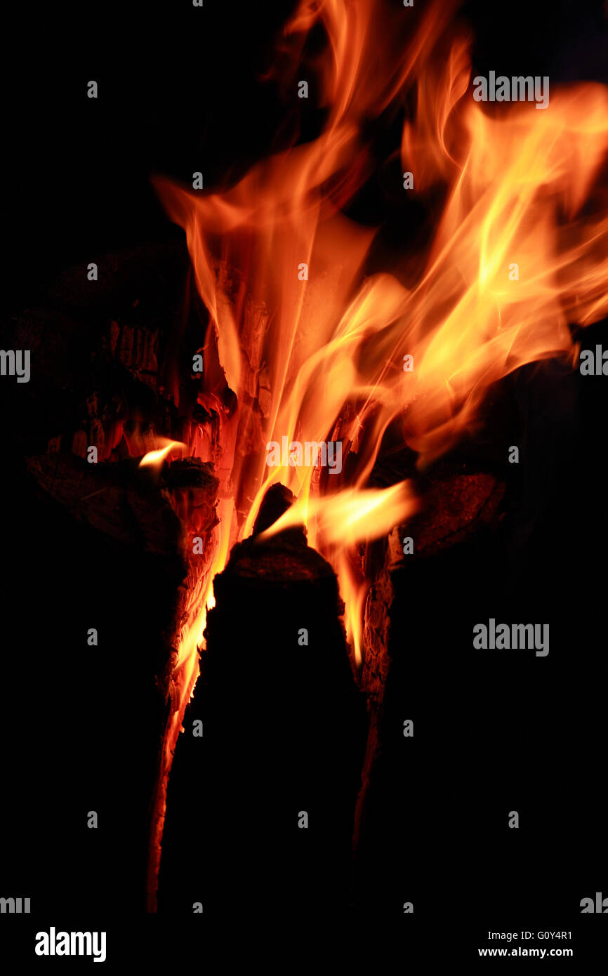 Closeup of burning log on dark background Stock Photo - Alamy