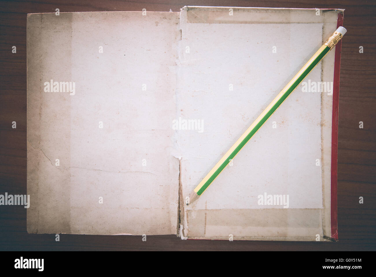 Vintage book and pencil, open on wooden background Stock Photo - Alamy