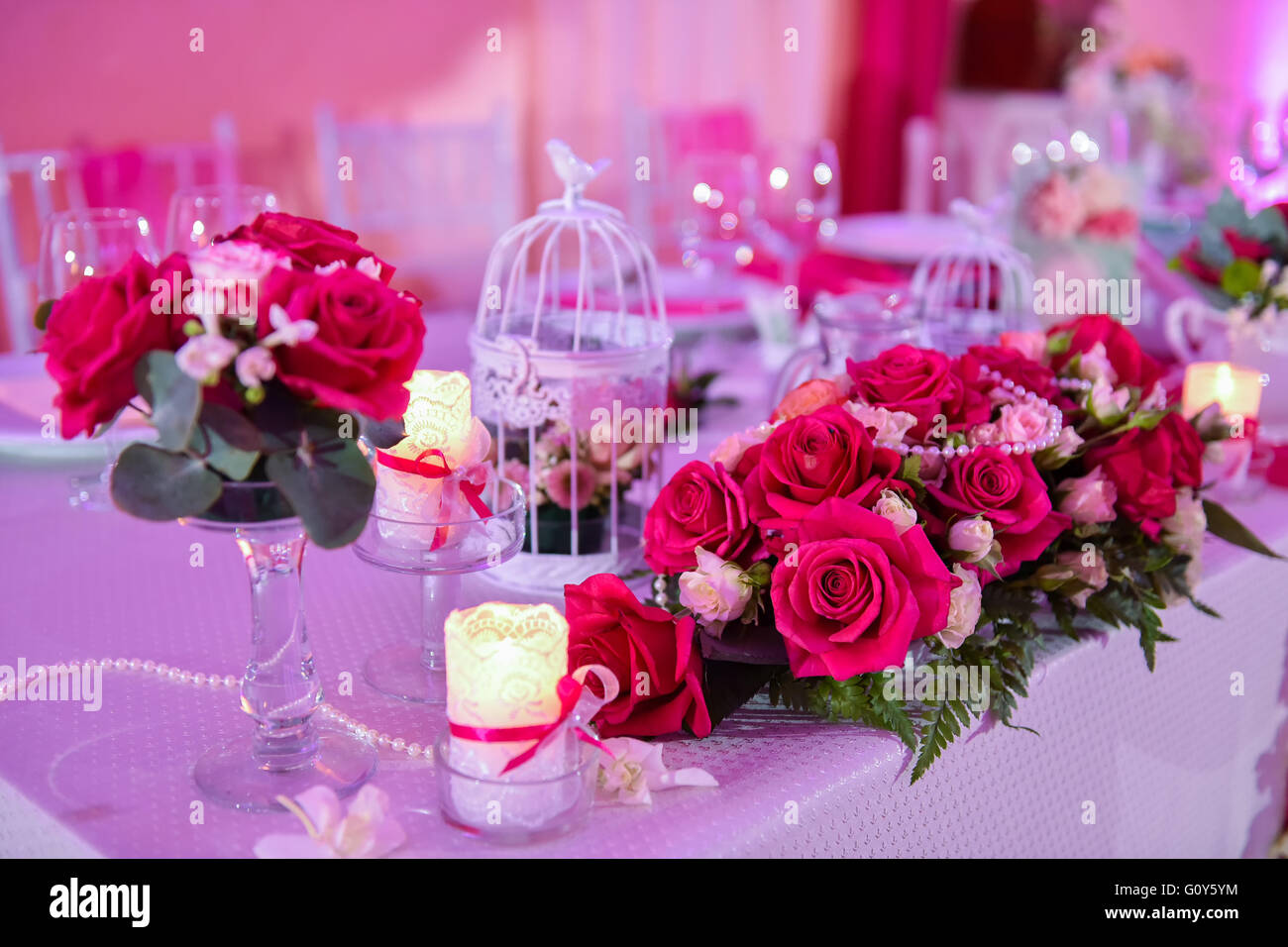 Roses on a wedding table with candles Stock Photo - Alamy
