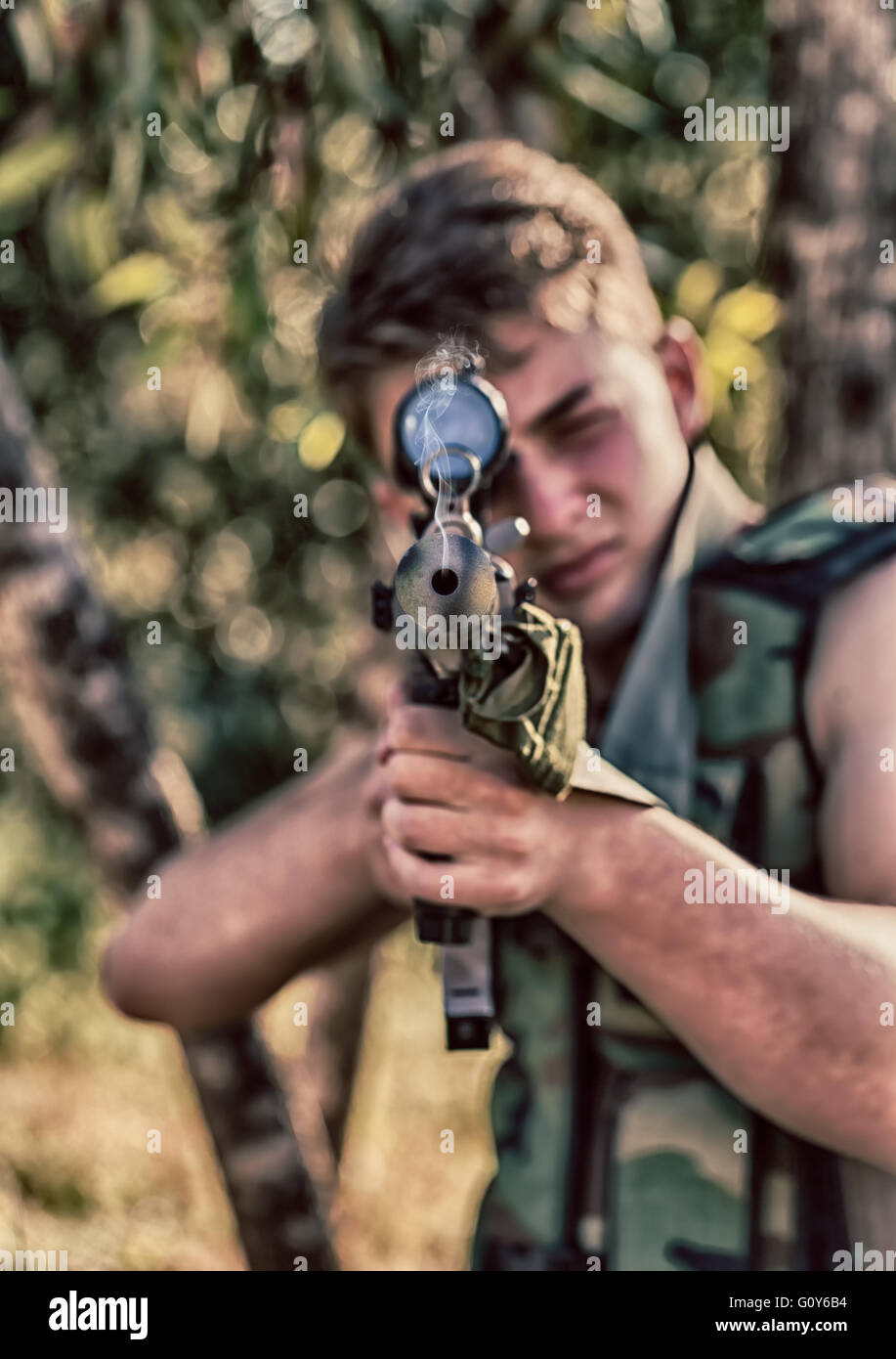 young a soldier in the uniform with weapon Stock Photo - Alamy