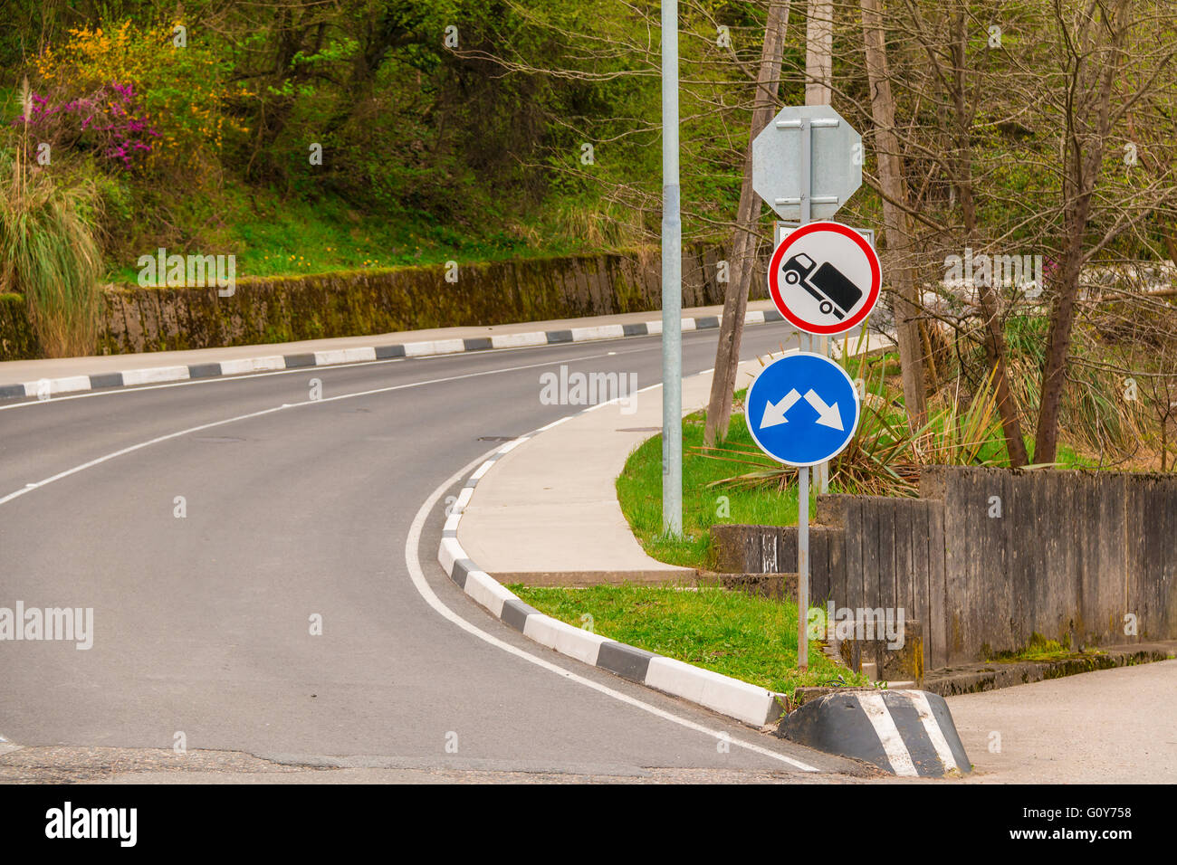 Turn on mountain road leading up with road signs Stock Photo - Alamy