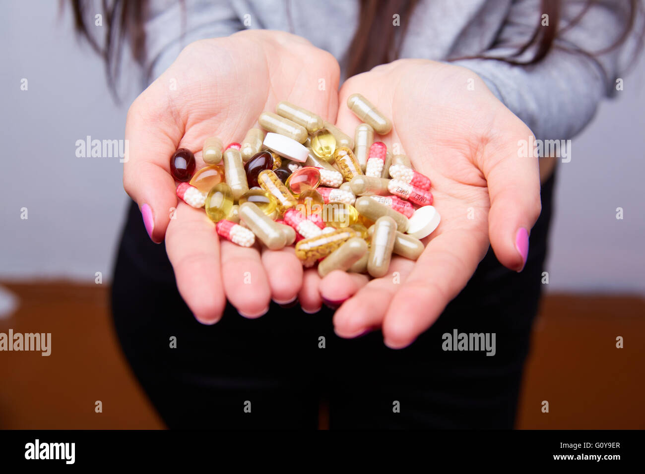 lot of pills and capsules in female hands Stock Photo - Alamy