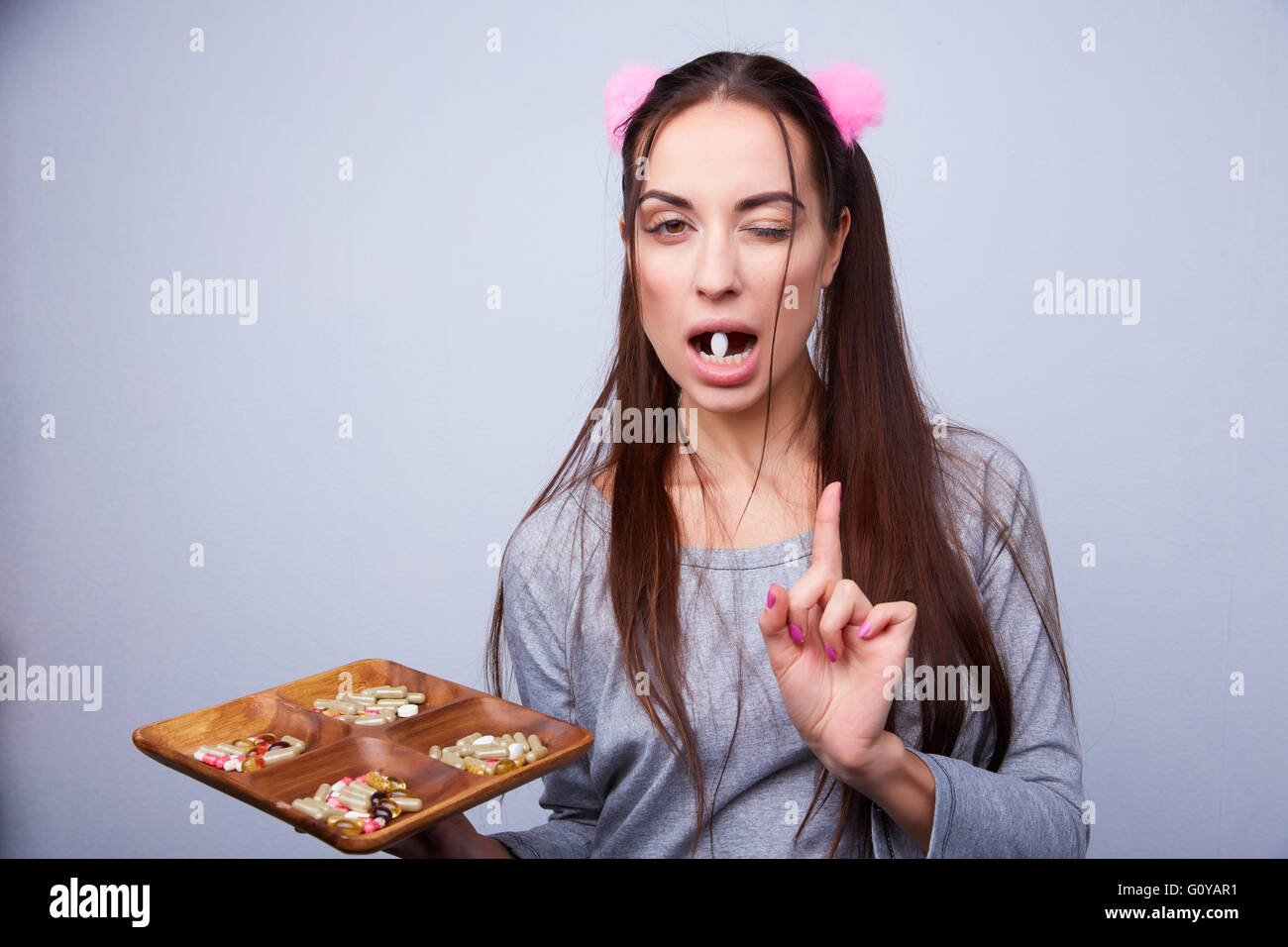 fun girl drinks a lot of pills Stock Photo - Alamy