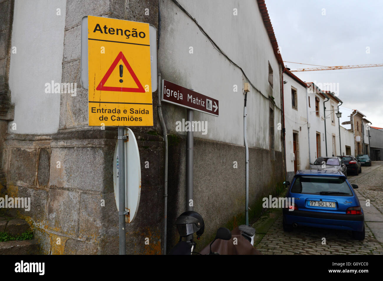 Sign in Portuguese warning of trucks entering and leaving via entrance ...