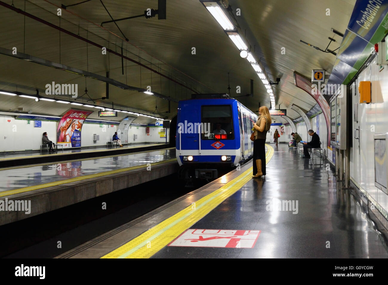 Blonde woman standing and reading tablet on platform as train ...