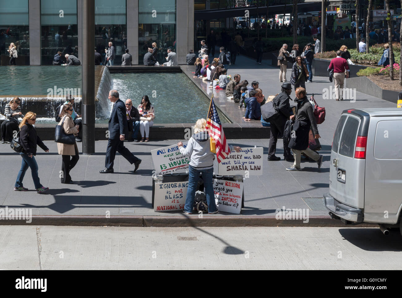 People walk past a lone female American protester/ activist in New York ...