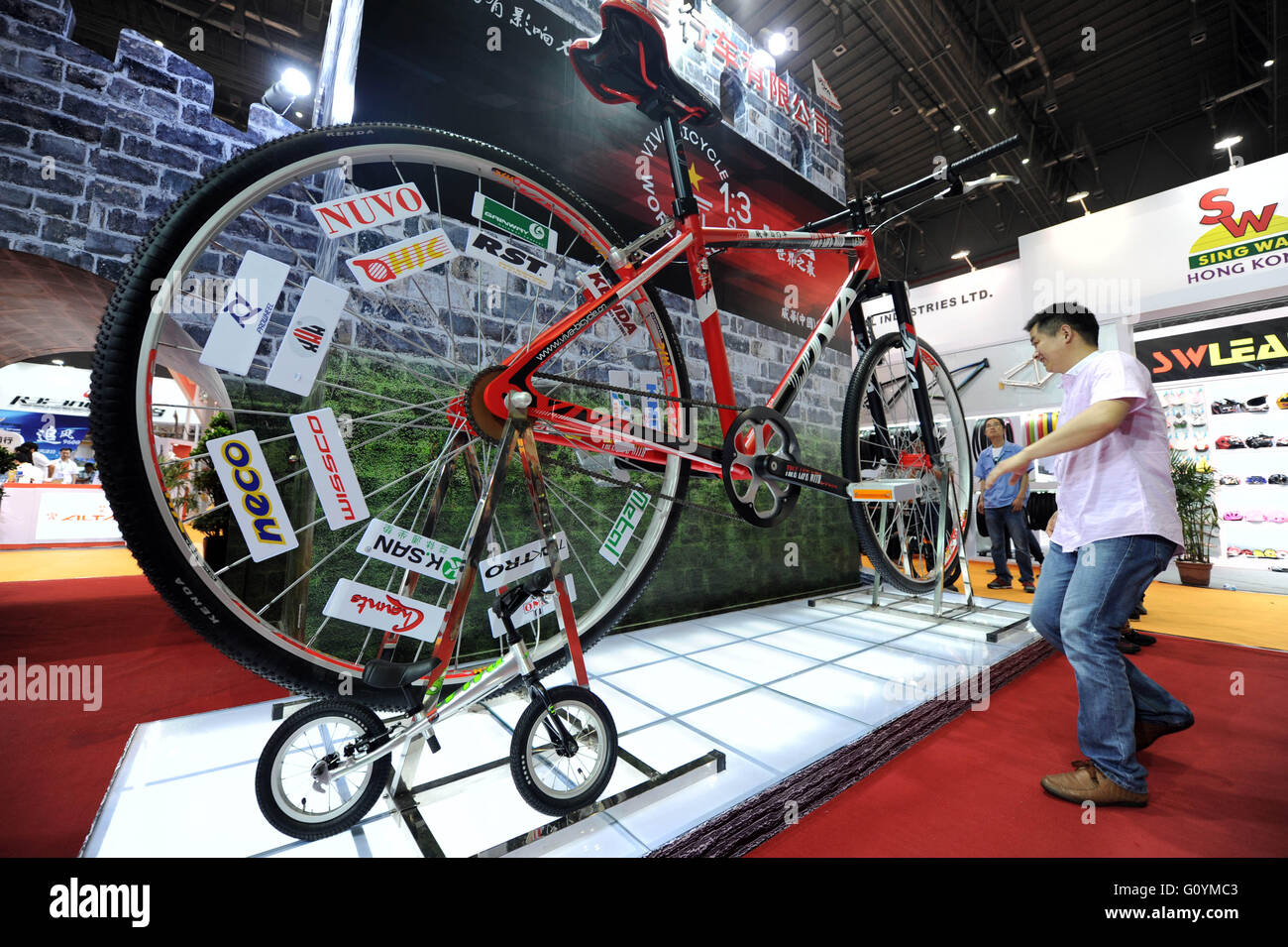 Shanghai. 6th May, 2016. Visitors look at a giant bicycle enlarged on ...