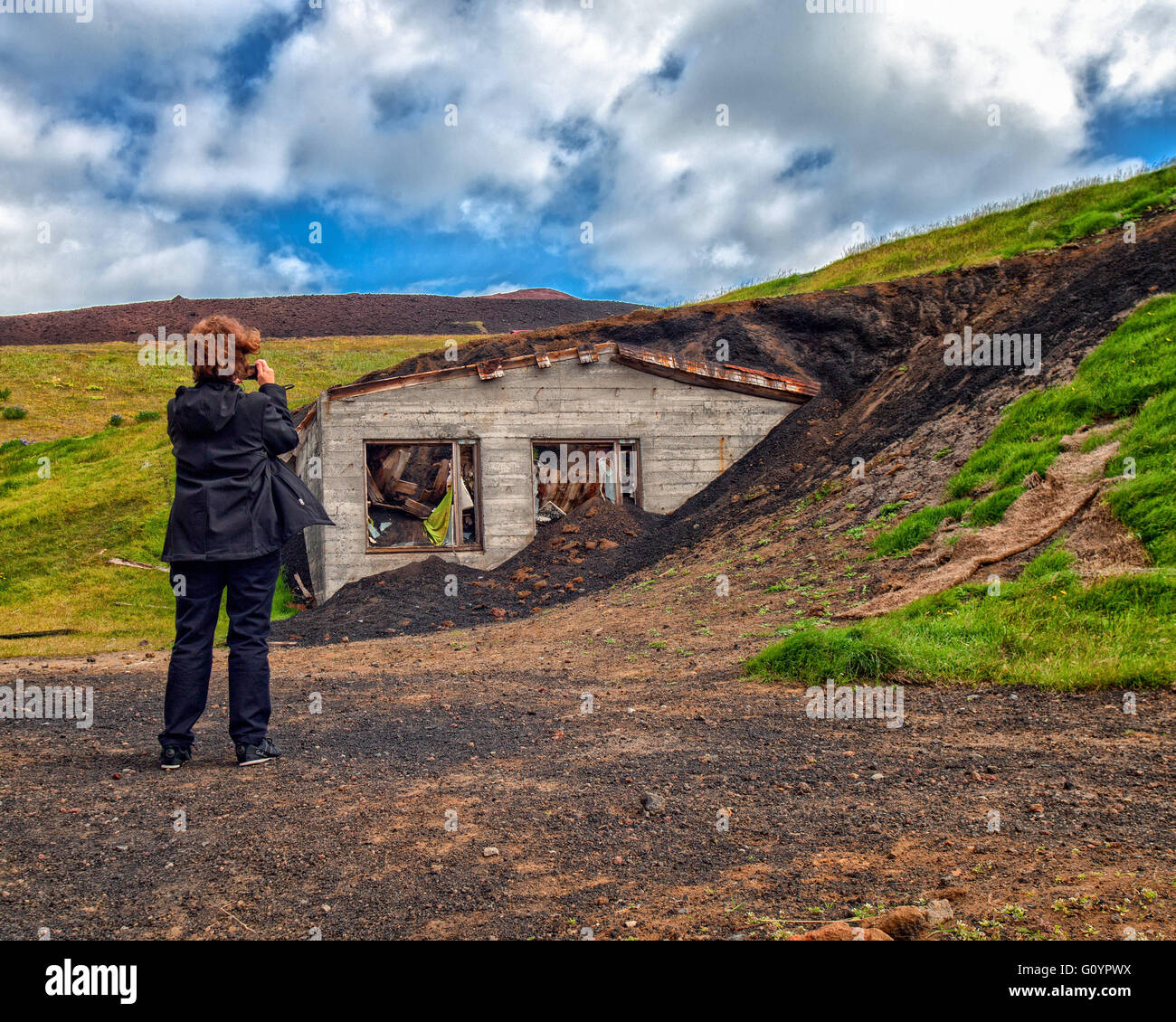 August 3, 2015 - Woman tourist photographs partially buried house ...