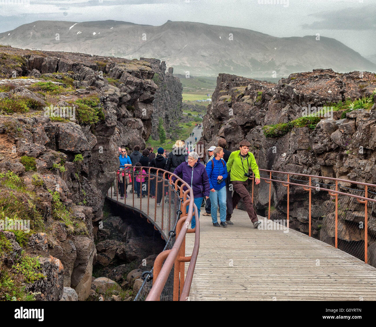 Southwest Iceland, Iceland. 4th Aug, 2015. Tourists walk on a bridge ...