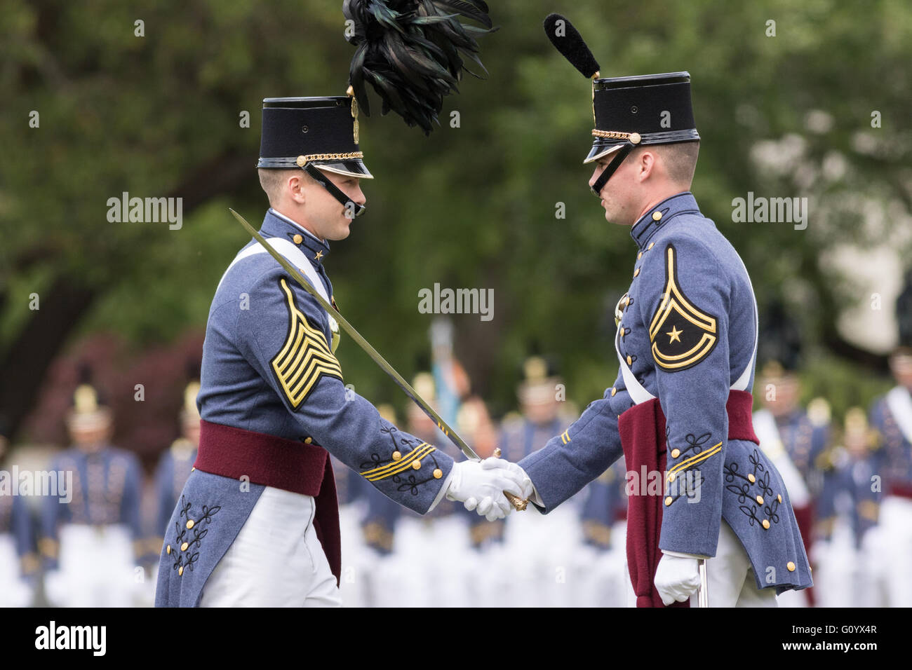 Graduating senior cadet leader, left, hands over his sword to his ...