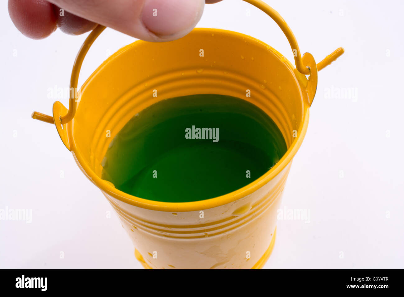 Water flowing out of little yellow bucket Stock Photo - Alamy