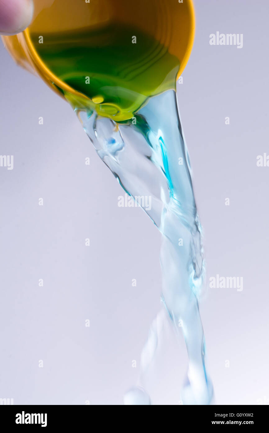 Water flowing out of little yellow bucket Stock Photo - Alamy