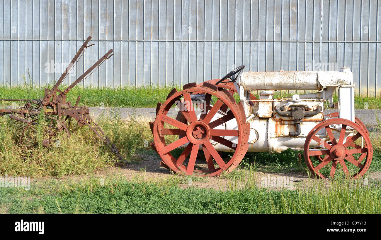 Old white tractor rusting away at old farm equipment graveyard Stock ...