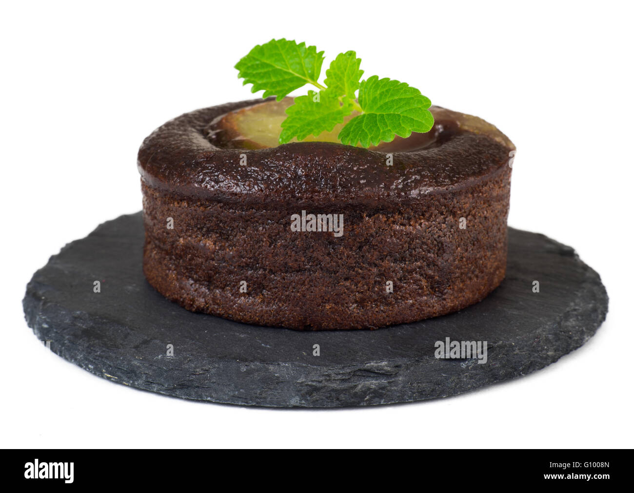 Chocolate cake served on modern slate plate with mint leaf isolated on ...