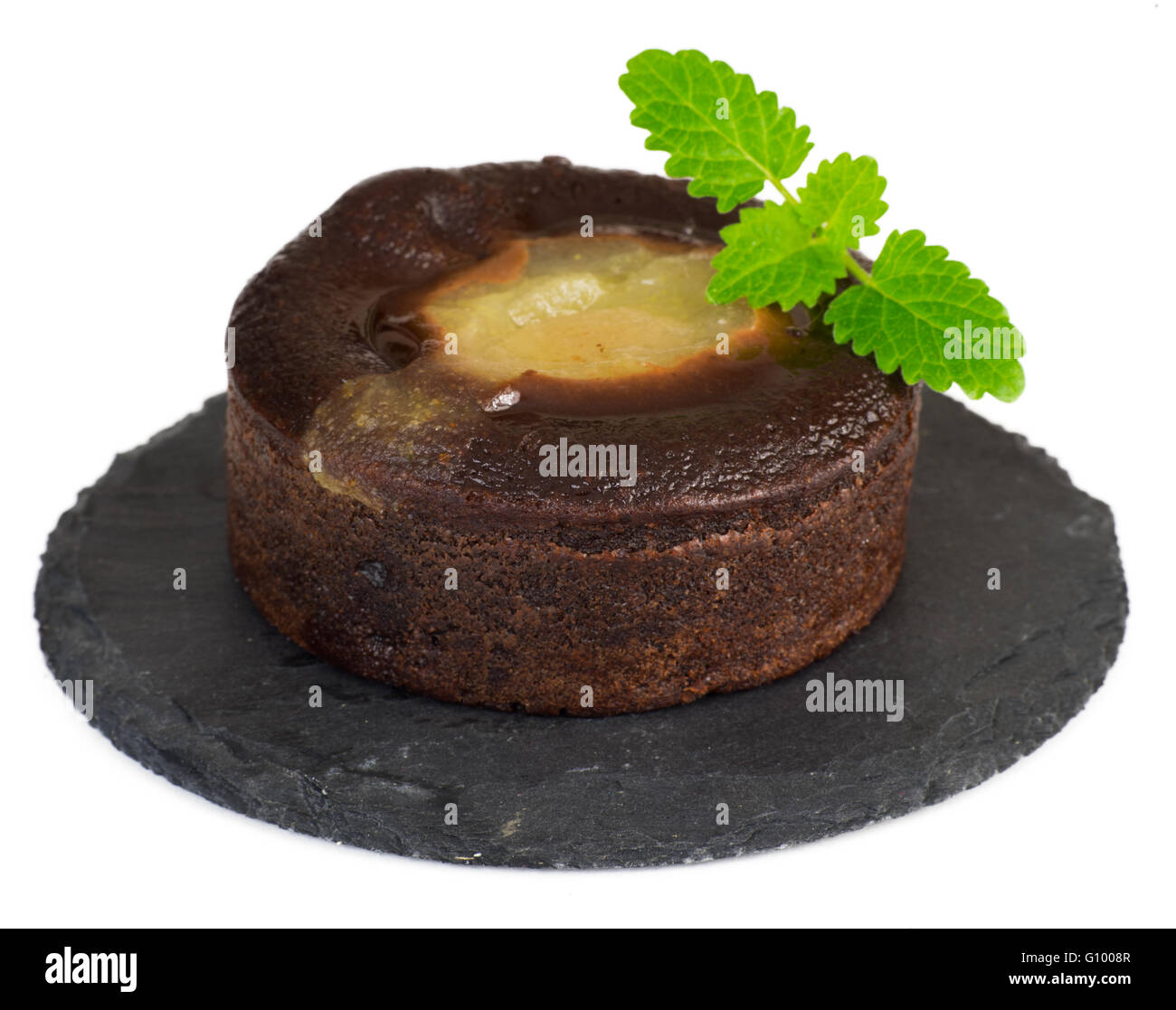 Chocolate cake served on modern slate plate with mint leaf isolated on ...