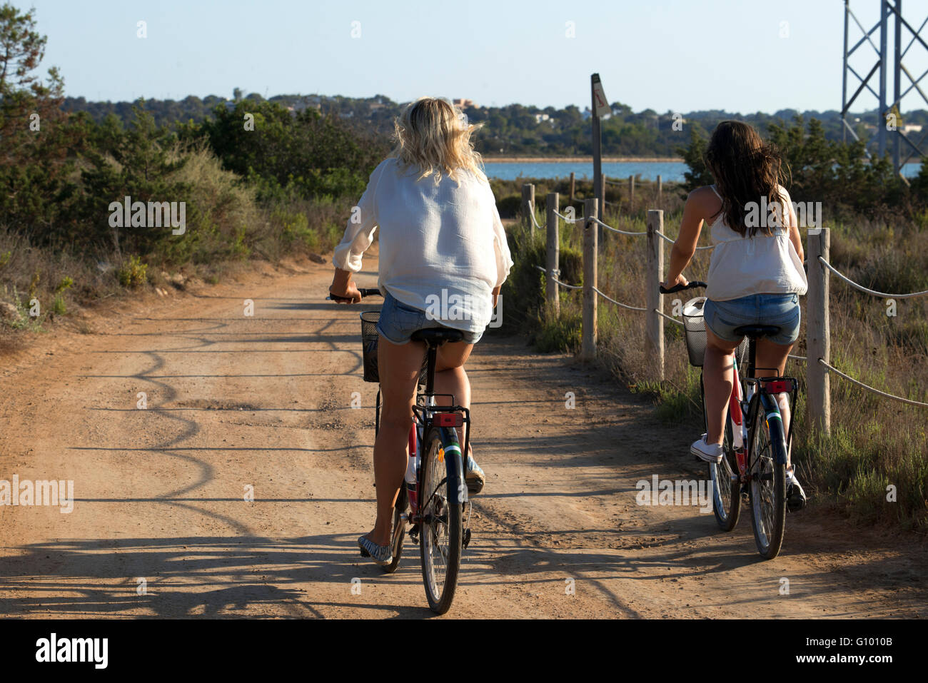 Girls riding in a bike pudent lake formentera balearic islands hi-res ...