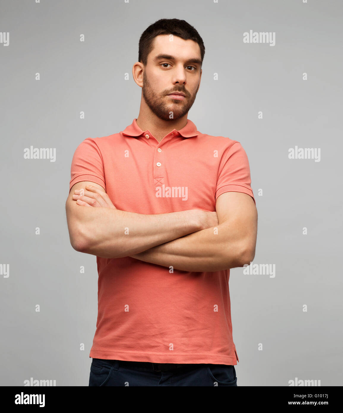 young man with crossed arms over gray background Stock Photo - Alamy