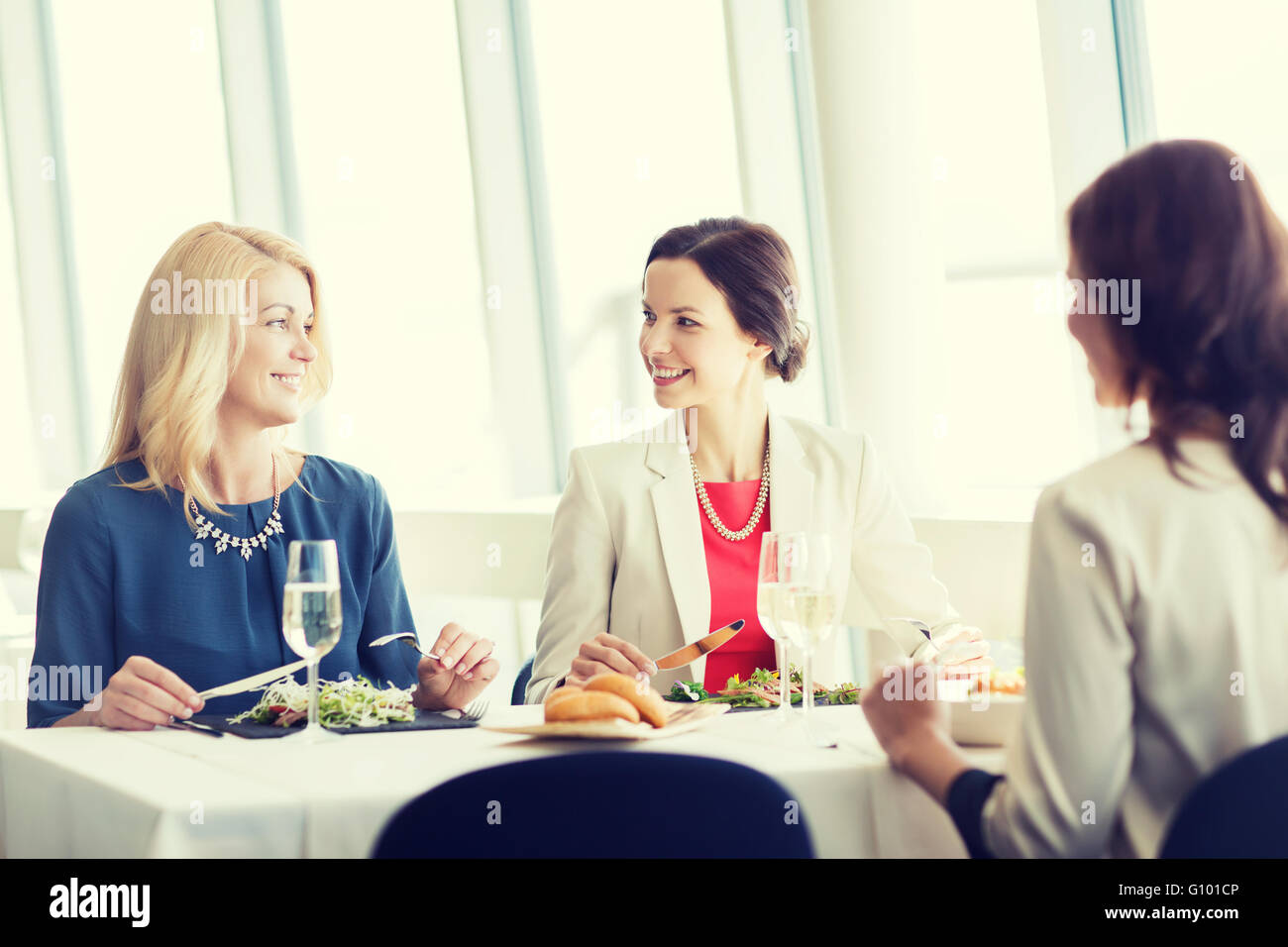 happy women eating and talking at restaurant Stock Photo - Alamy