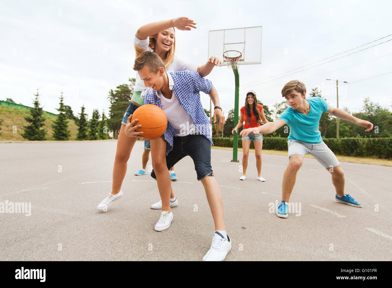 group of happy teenagers playing basketball Stock Photo - Alamy