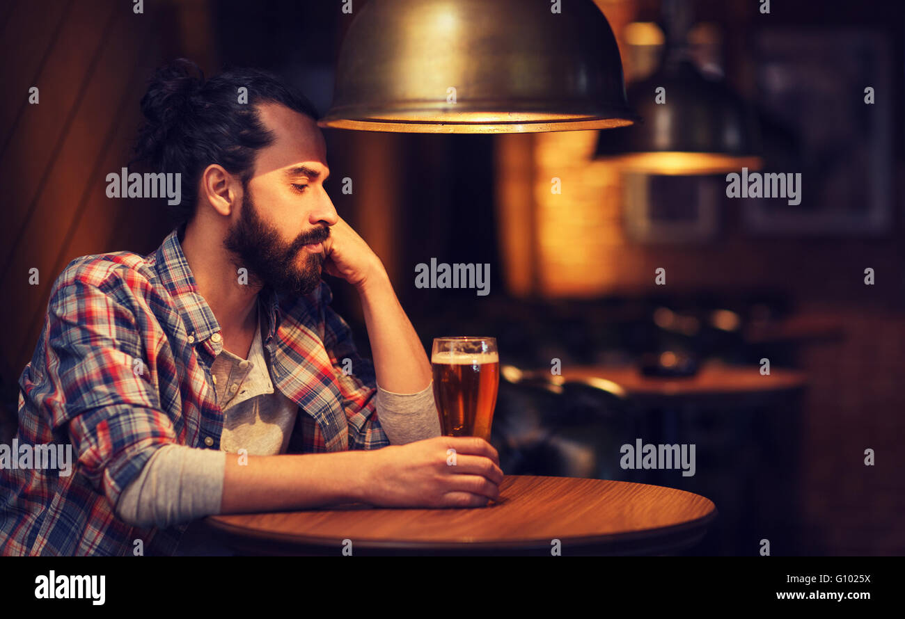 unhappy lonely man drinking beer at bar or pub Stock Photo - Alamy