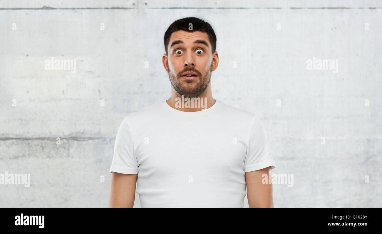 scared man in white t-shirt over wall background Stock Photo - Alamy