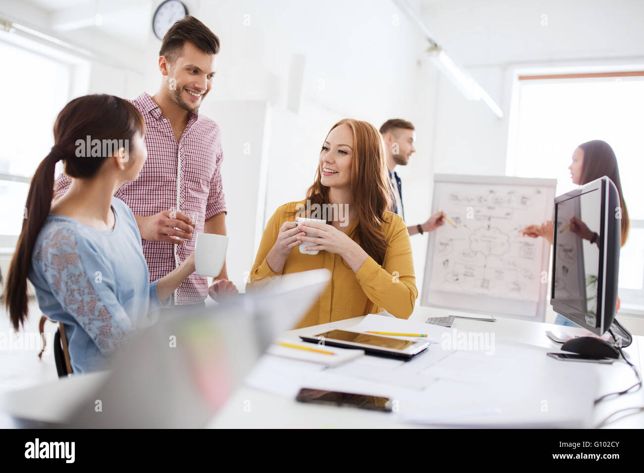 happy creative team drinking coffee at office Stock Photo - Alamy
