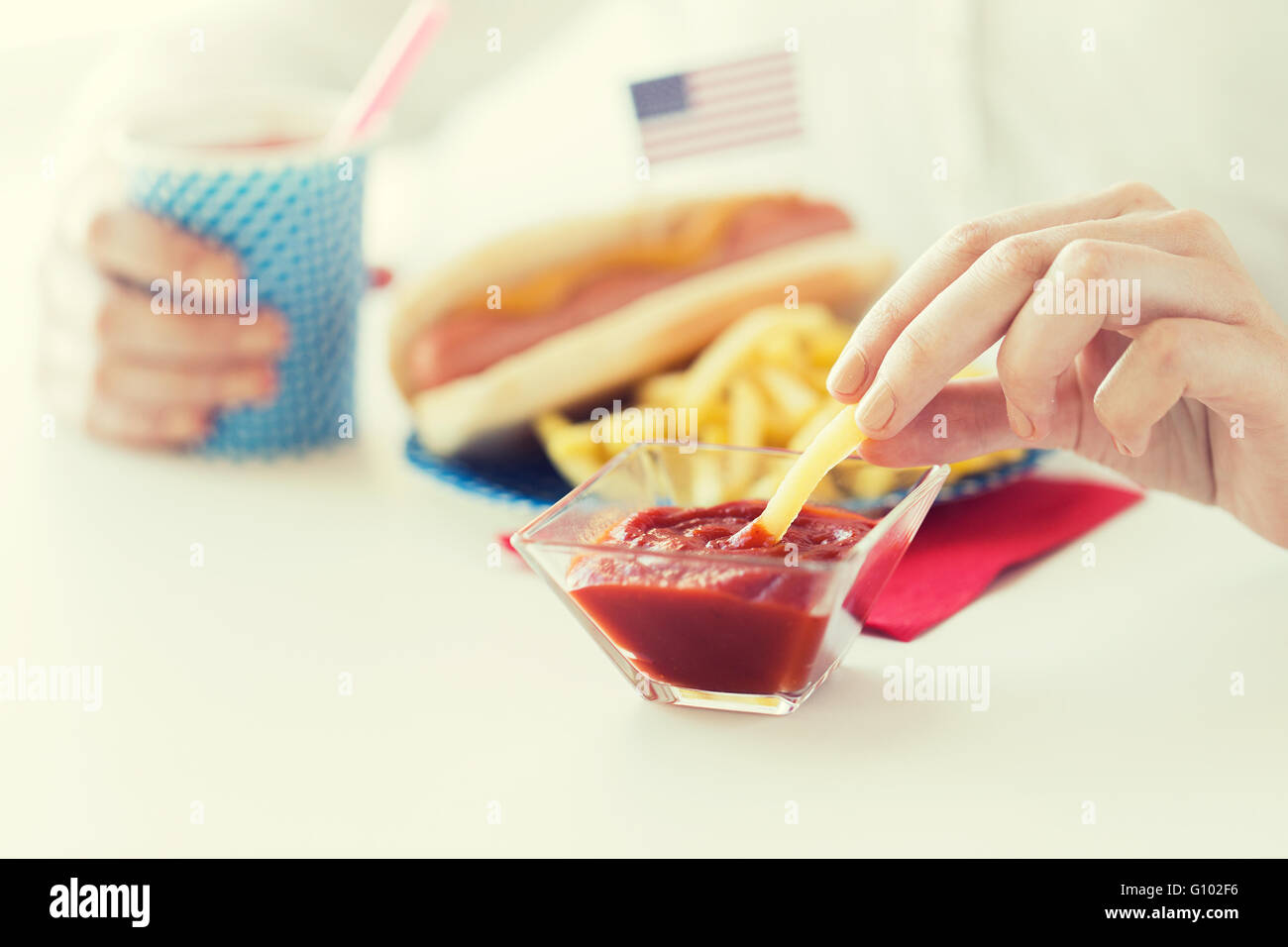 close up of woman hands eating on american food Stock Photo - Alamy